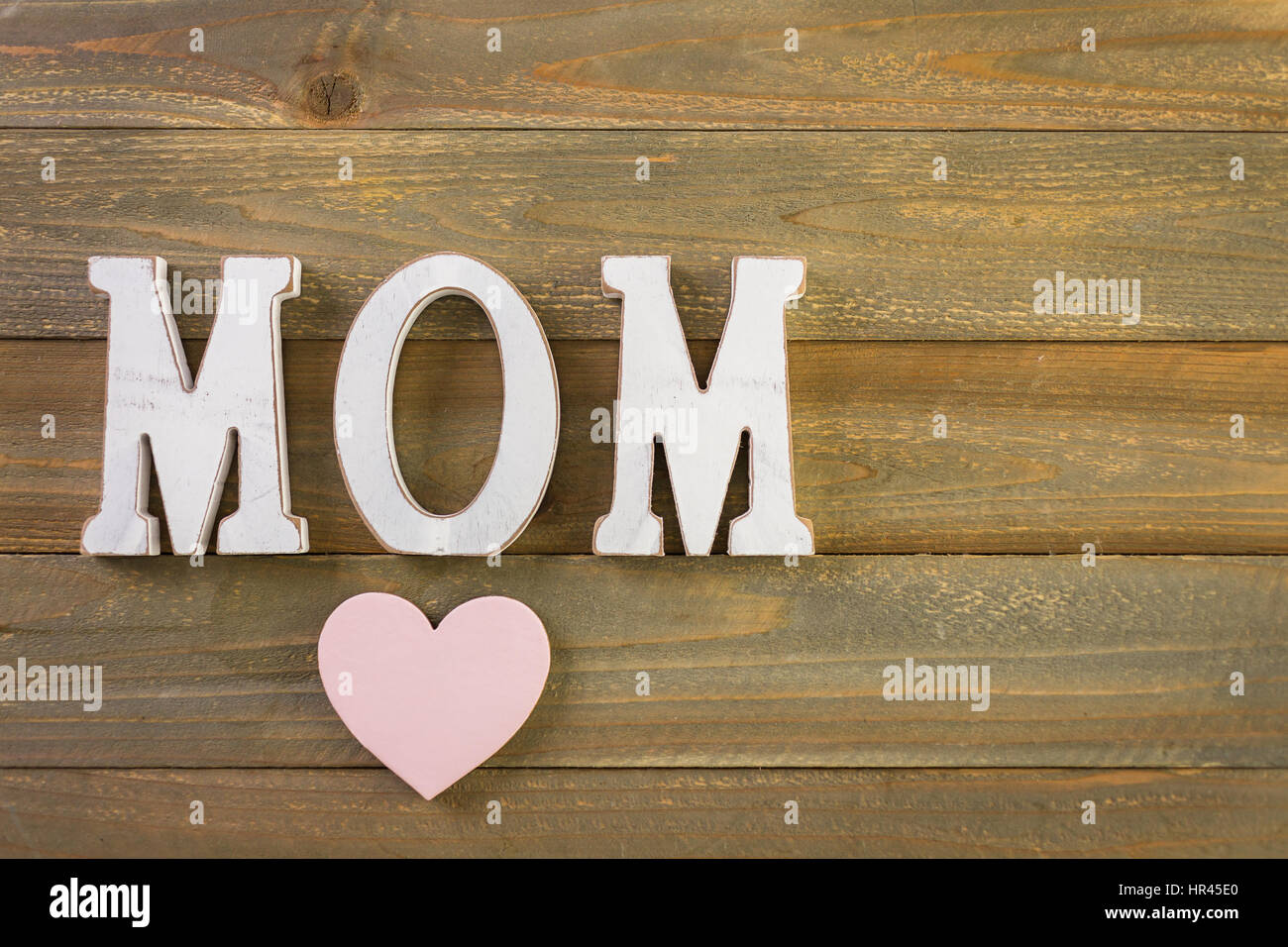 White letters MOM on a painted wood background Stock Photo - Alamy