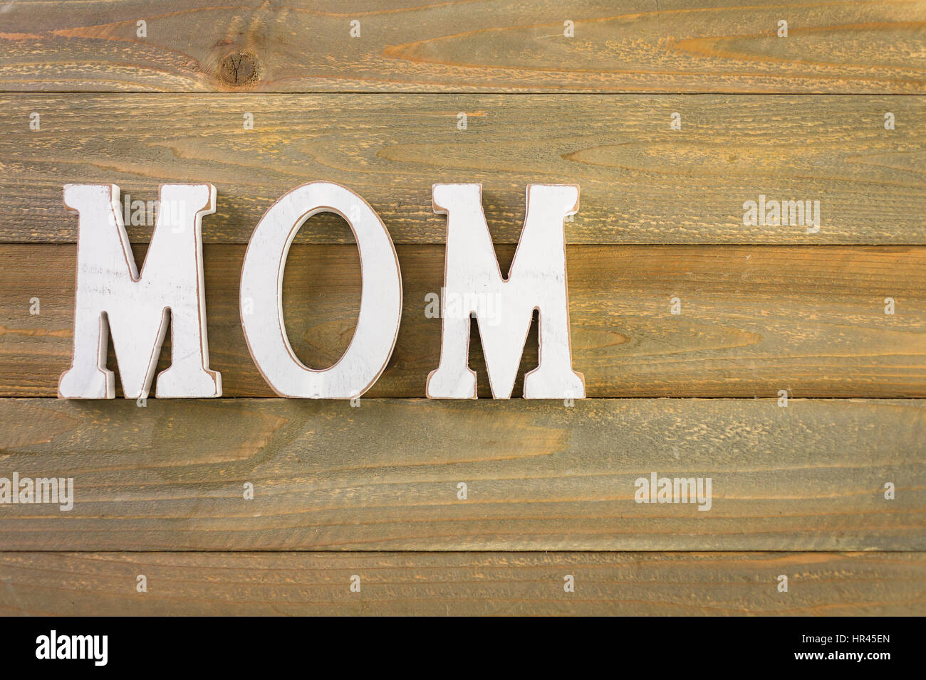 White letters MOM on a painted wood background Stock Photo - Alamy
