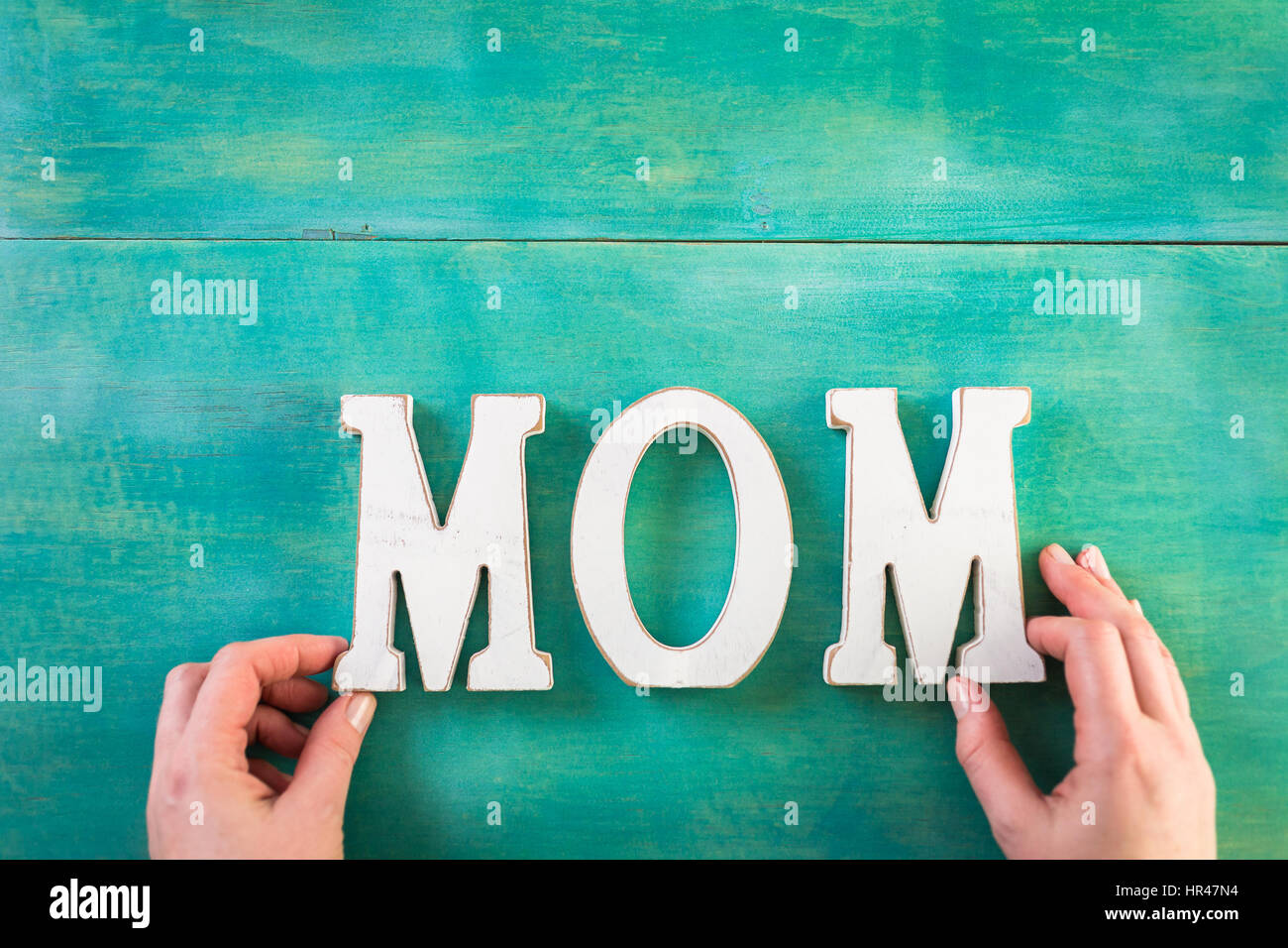 White letters MOM on a painted wood background Stock Photo - Alamy
