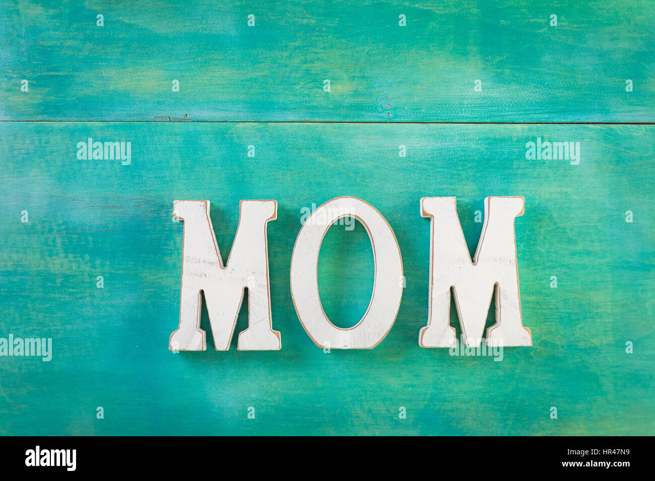 White letters MOM on a painted wood background Stock Photo - Alamy