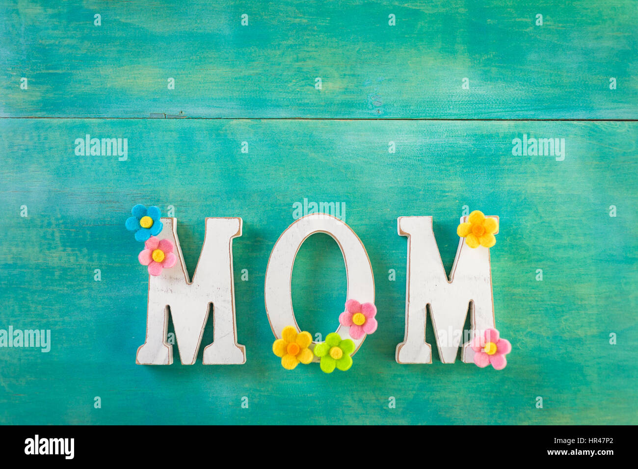 White letters MOM on a painted wood background Stock Photo - Alamy
