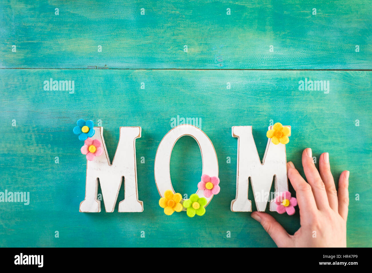 White letters MOM on a painted wood background Stock Photo - Alamy