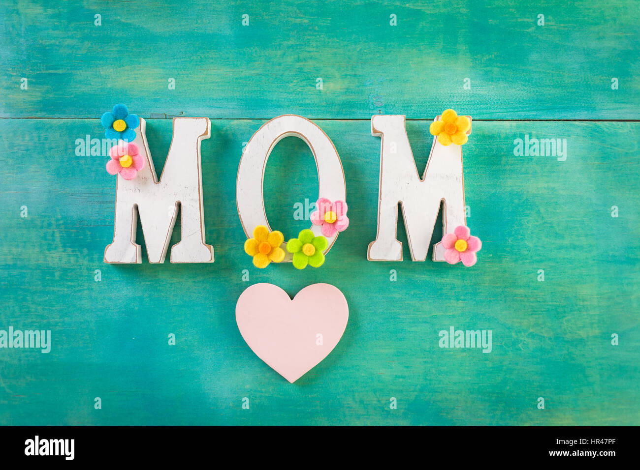 White letters MOM on a painted wood background Stock Photo - Alamy
