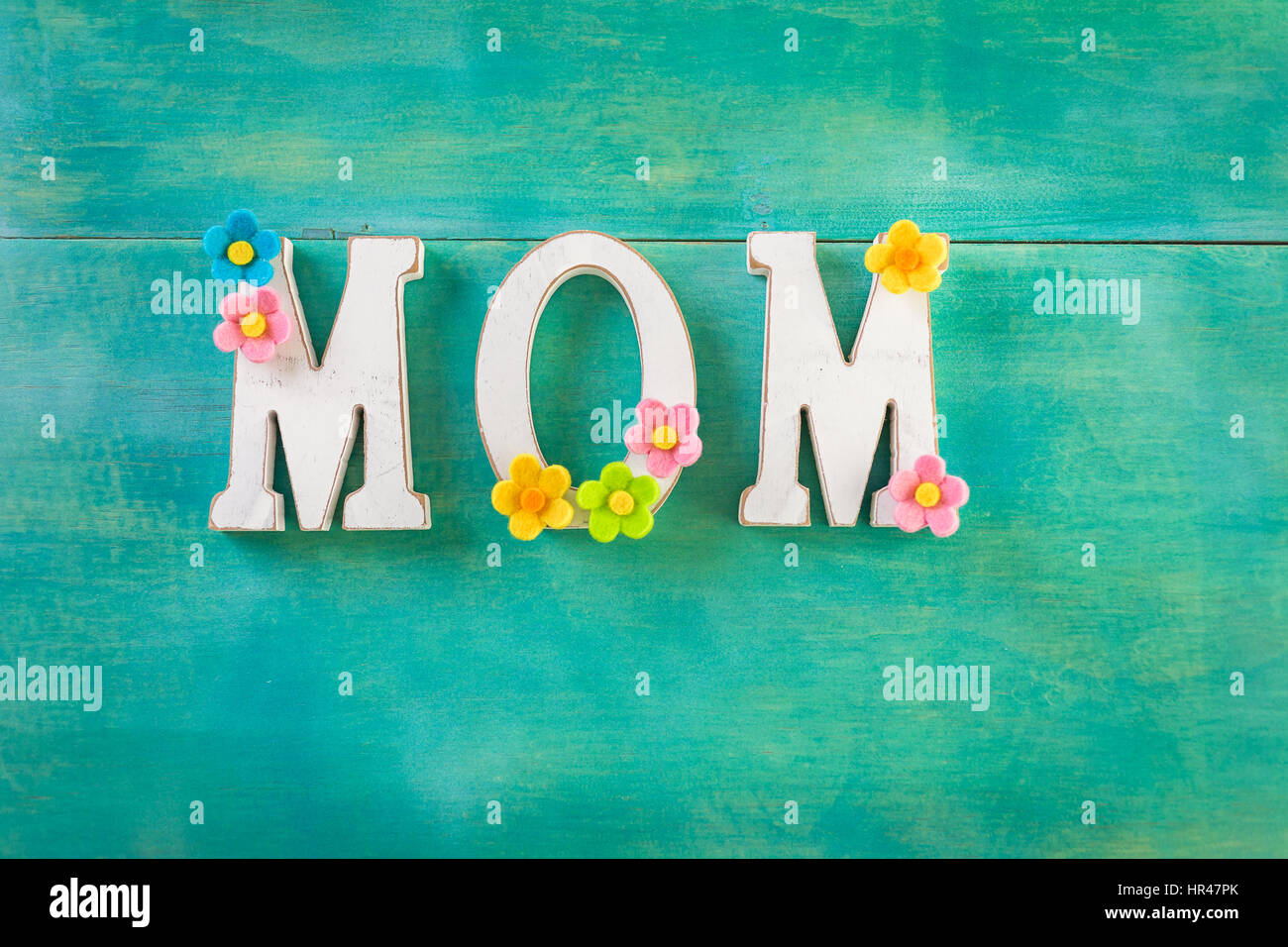 White letters MOM on a painted wood background Stock Photo - Alamy