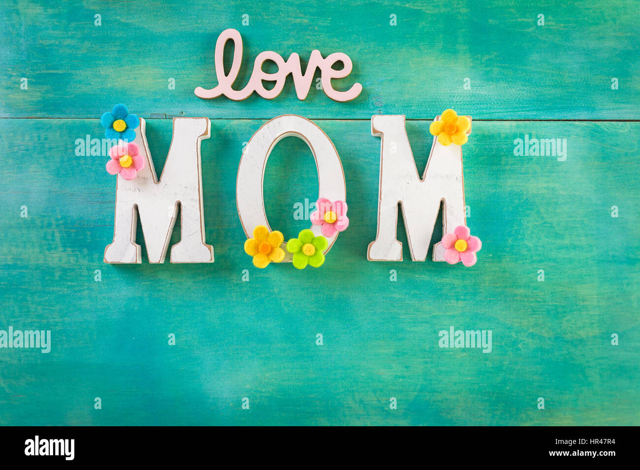 White letters MOM on a painted wood background Stock Photo - Alamy