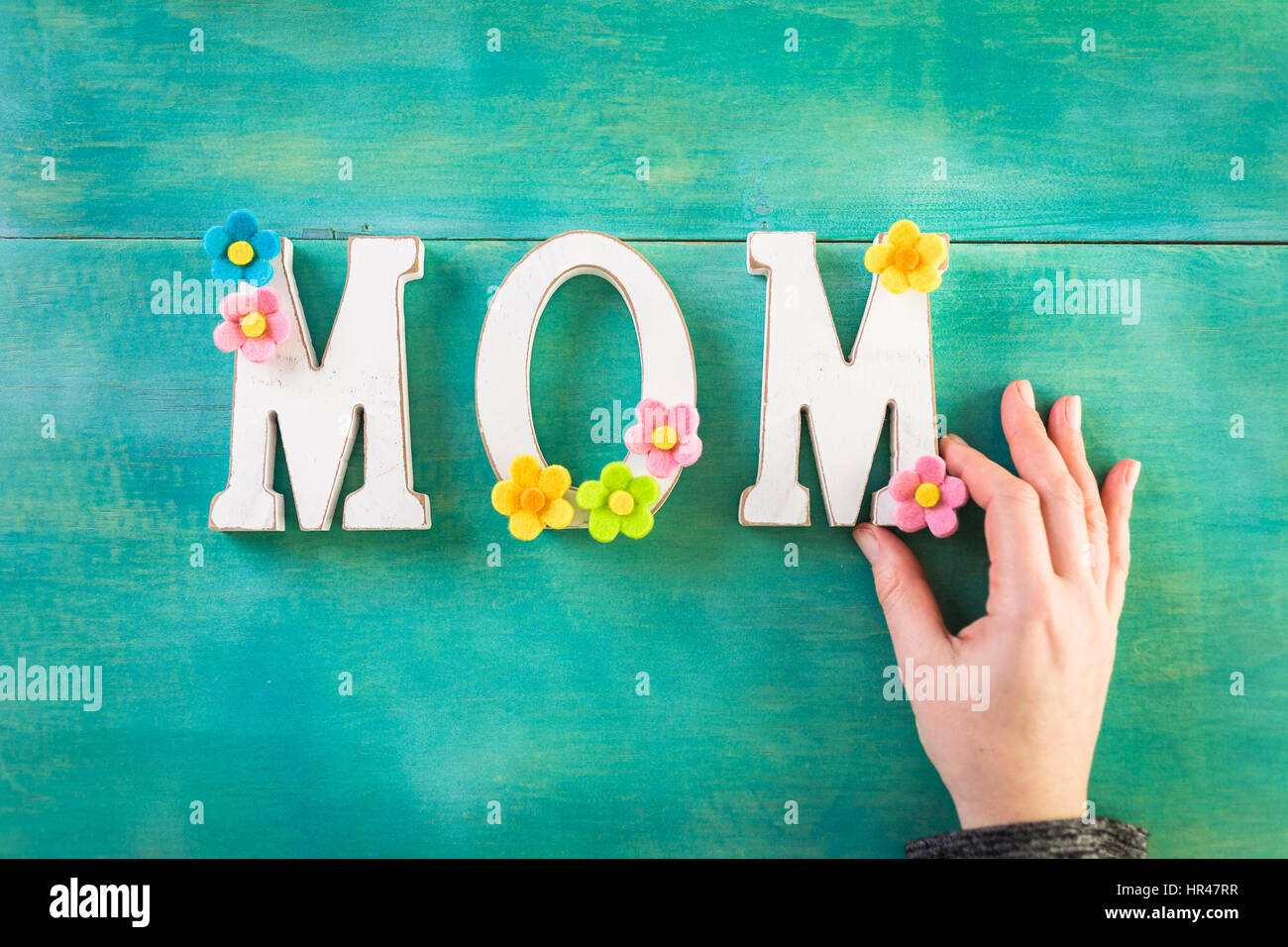 White letters MOM on a painted wood background Stock Photo - Alamy