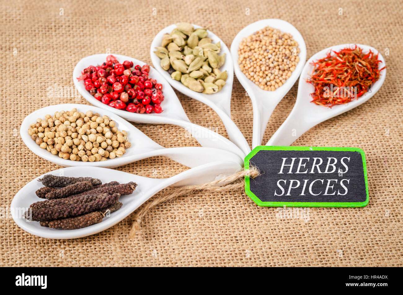 various spices and herbs with herbs spices label on sack background ...