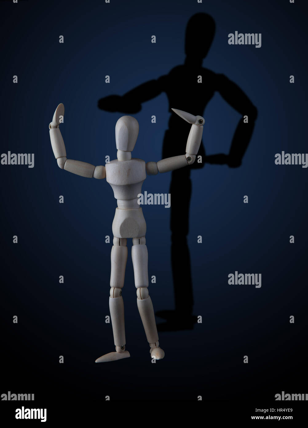 Wooden figurine flexing muscles in bodybuilder pose with shadow showing ...