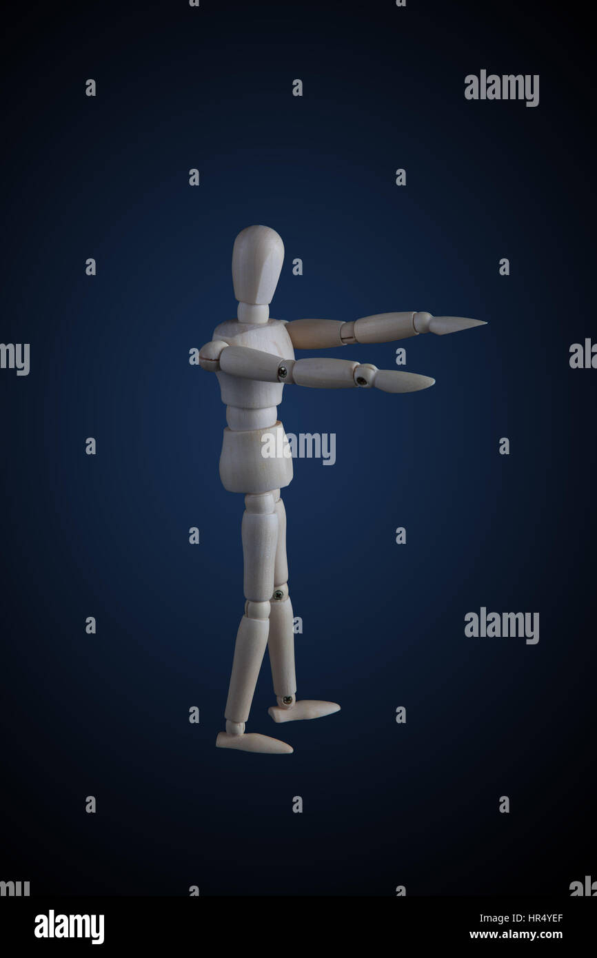 Wooden figurine stretching arms forward in zombie pose on dark ...