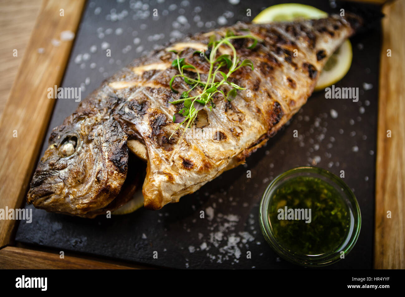 Grilled dorada fish with lemon and spinach Stock Photo - Alamy