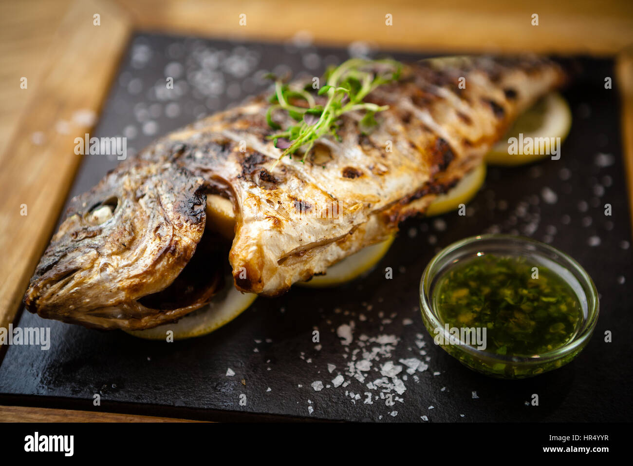 Grilled dorada fish with lemon and spinach Stock Photo - Alamy