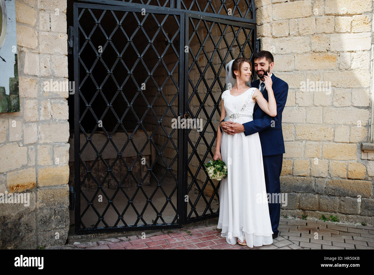 Wedding couple near old wrought iron gates Stock Photo - Alamy