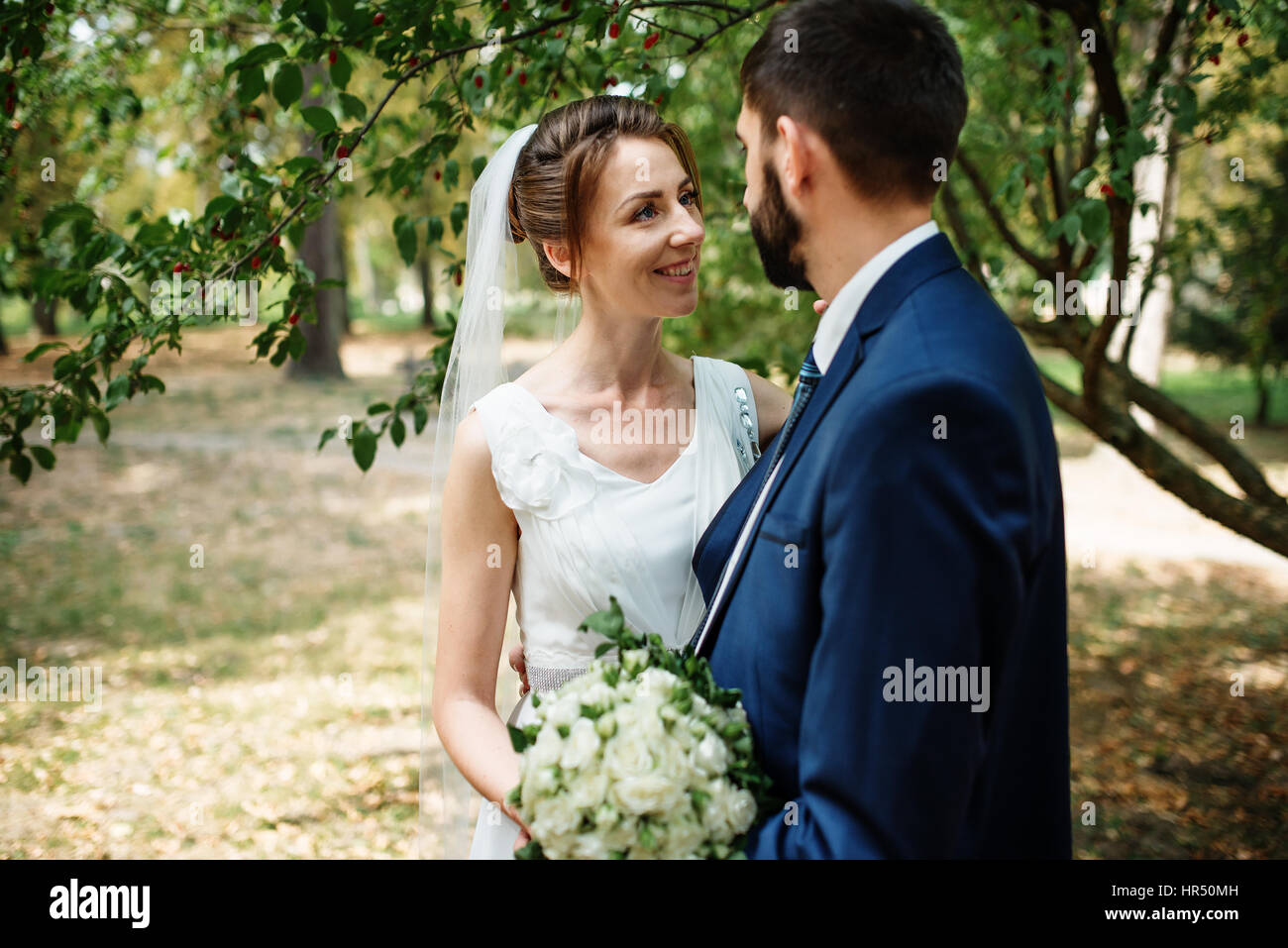 Wedding couple stay under tree at green park Stock Photo - Alamy