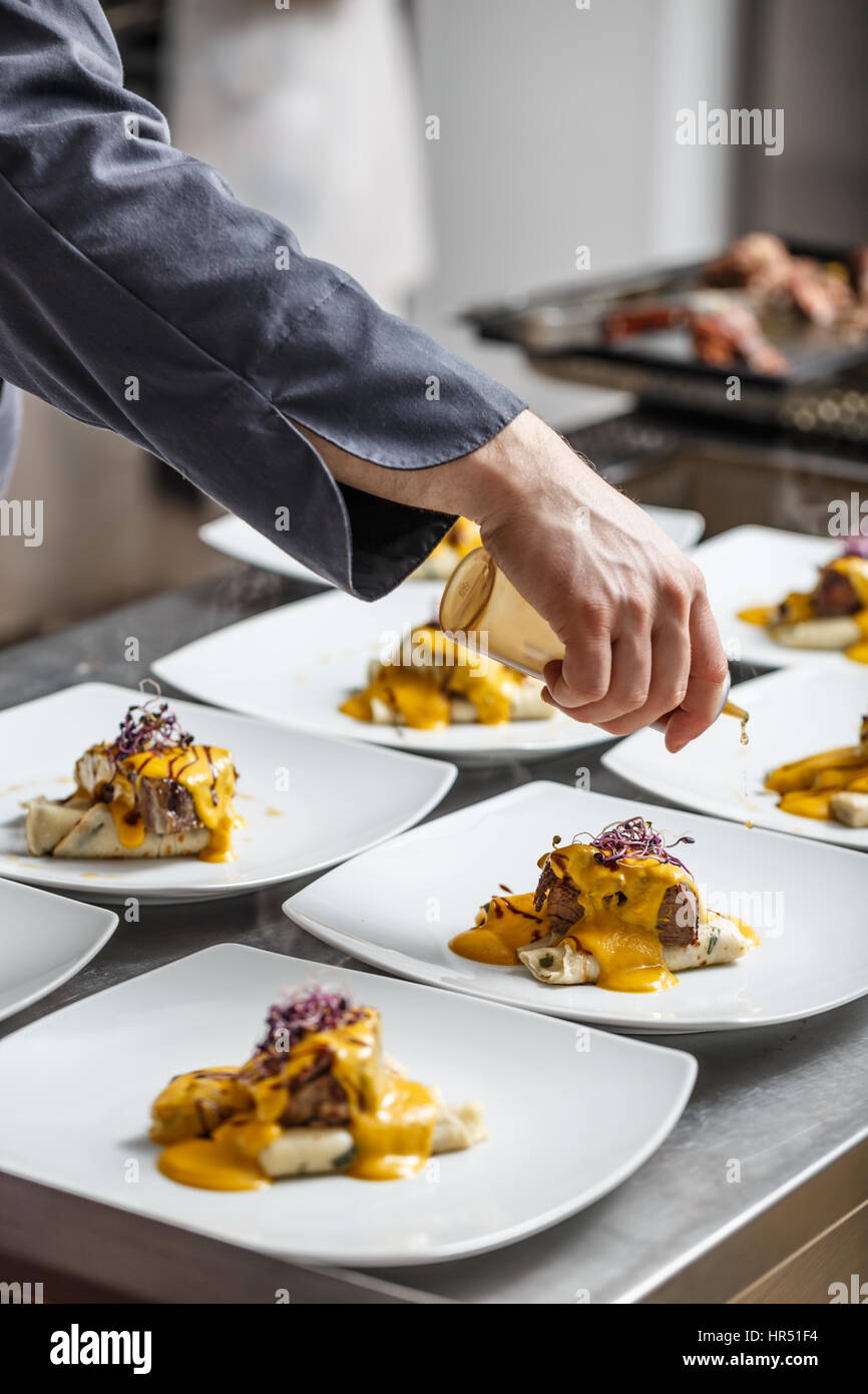 A line of freshly plated boiled beef meat garnish vwith pancakes and ...