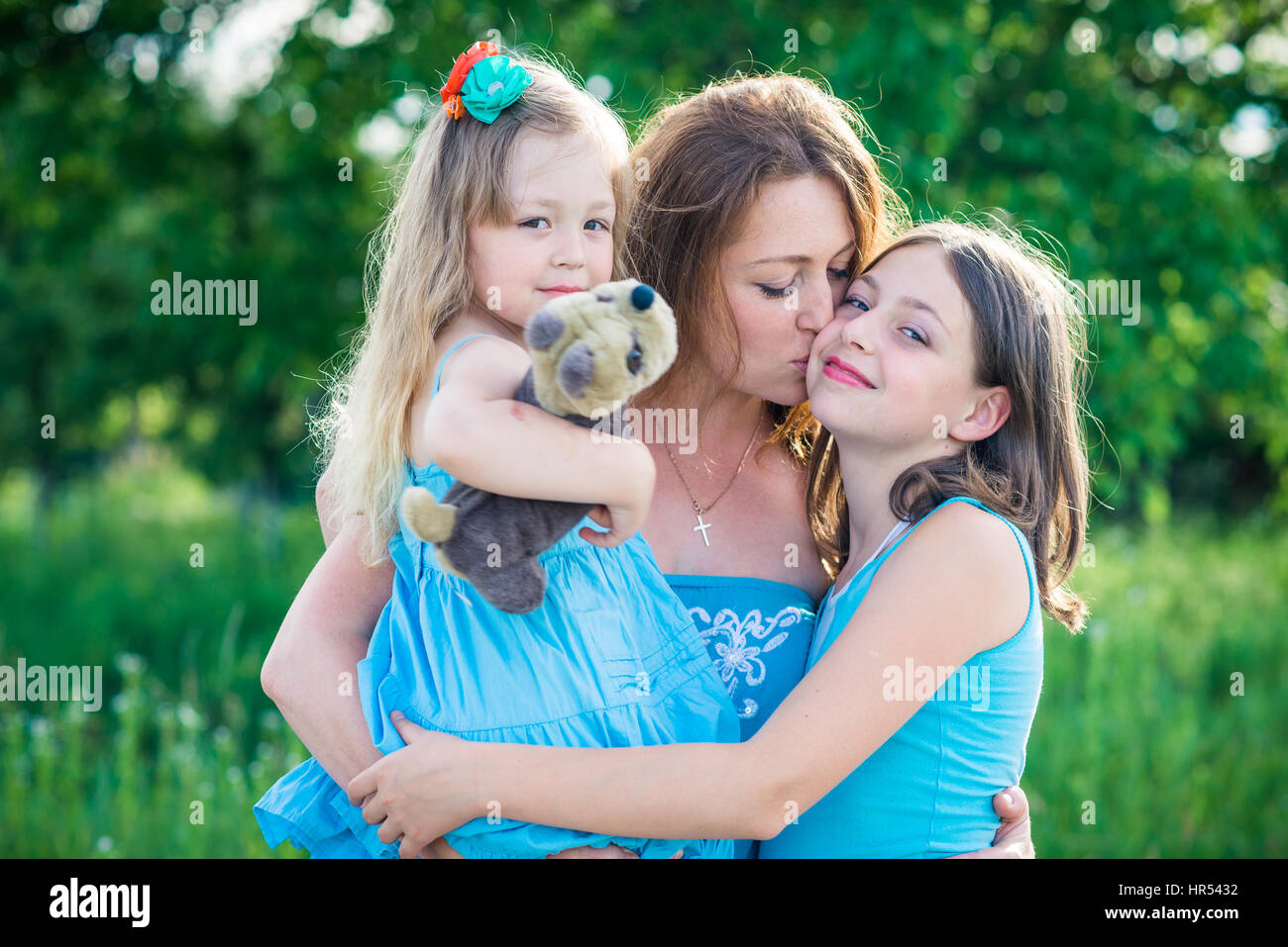 portrait of mother and two daughters. mother kissing daughter Stock ...