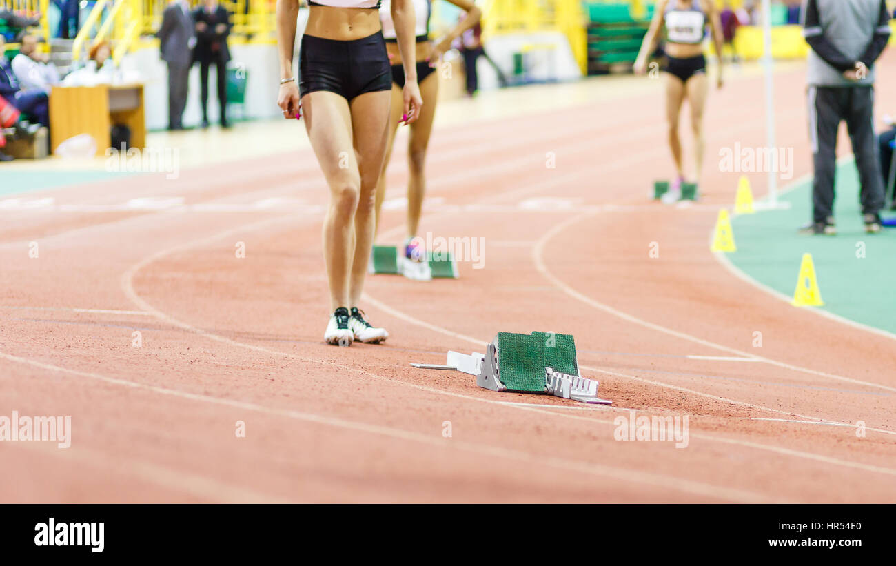 Sportswoman standing near starting blocks before sprint running event ...