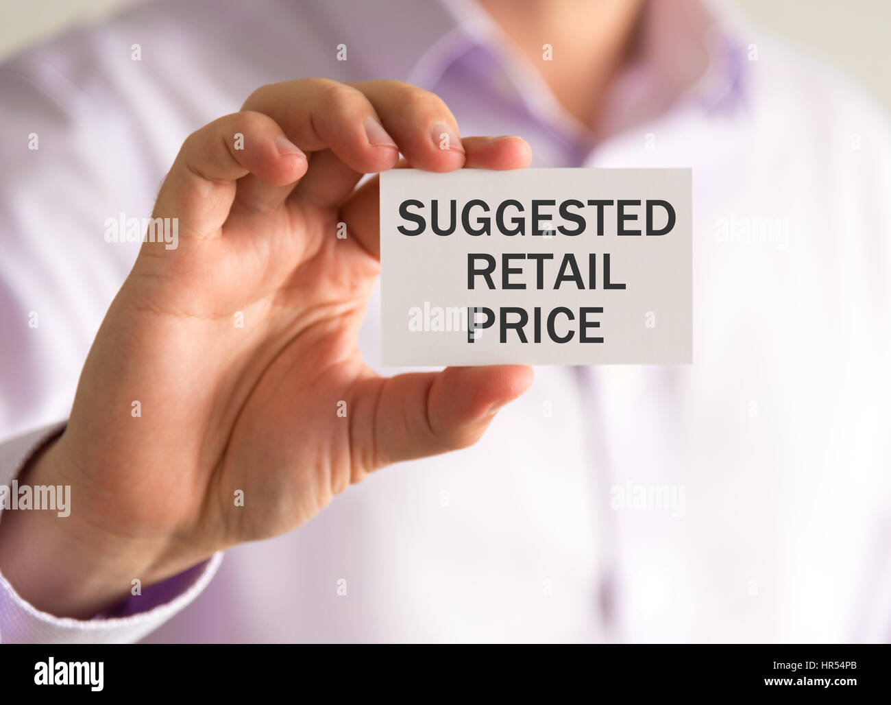 Closeup on businessman holding a card with SUGGESTED RETAIL PRICE ...