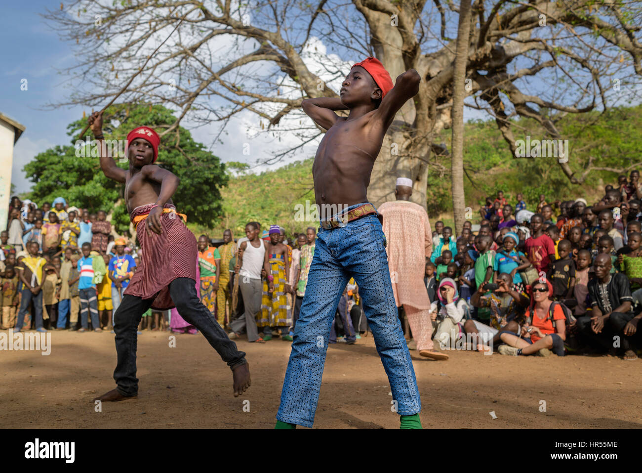 A Fulani boy hits his opponent with a whip made out of a branch. The ...