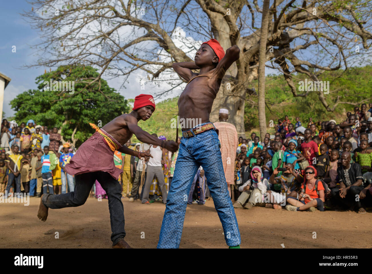 A Fulani boy hits his opponent with a whip made out of a branch. The ...