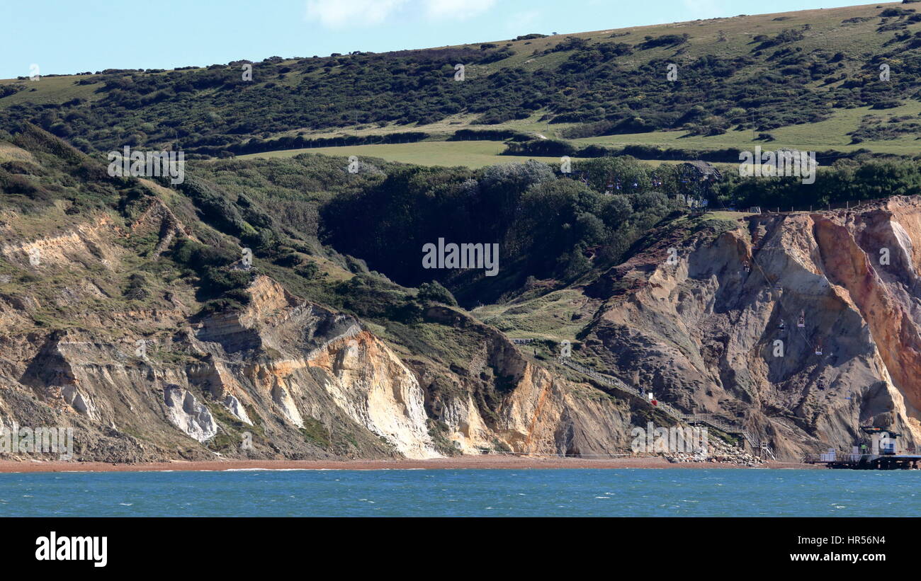 Richly colourful gnarled and weathered sandstone / limestone cliff face ...