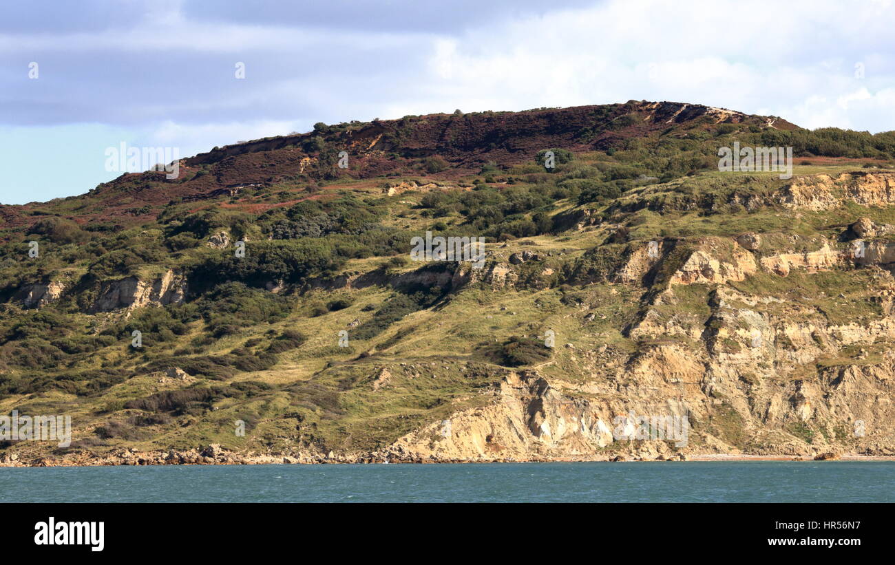 Richly colourful gnarled and weathered sandstone / limestone cliff face ...