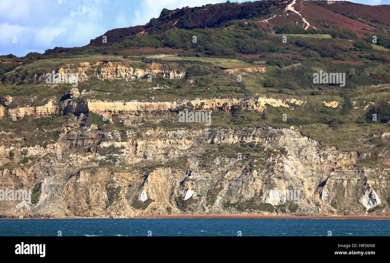 Richly colourful gnarled and weathered sandstone / limestone cliff face ...