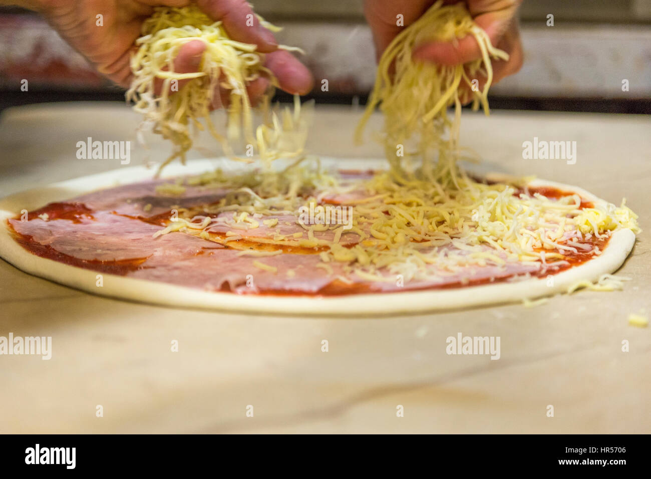 making pizza with your hands and add cheese Stock Photo - Alamy