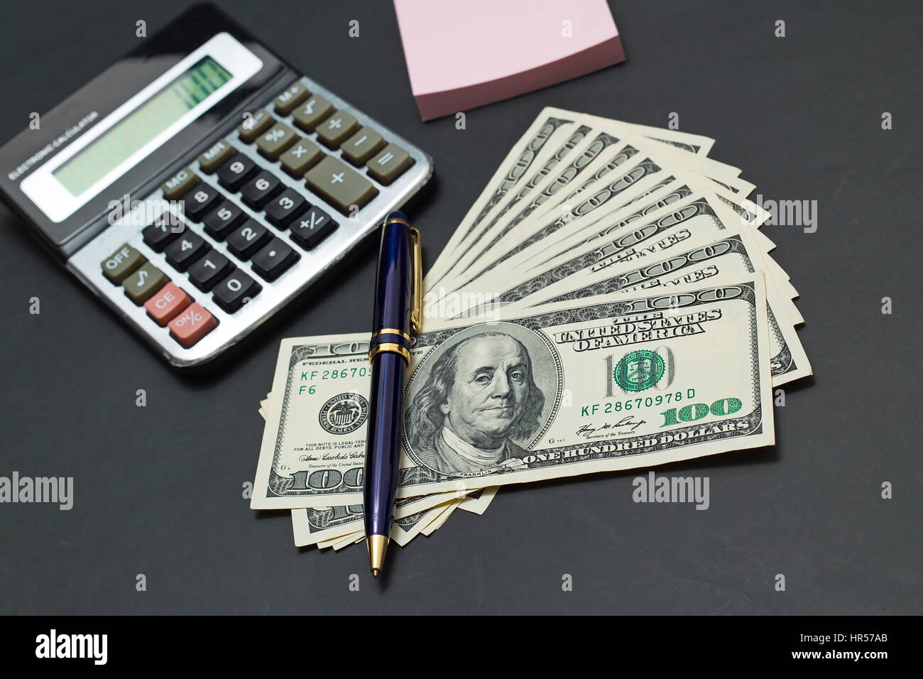 US Dollars on black office table with calculator and notebook Stock ...
