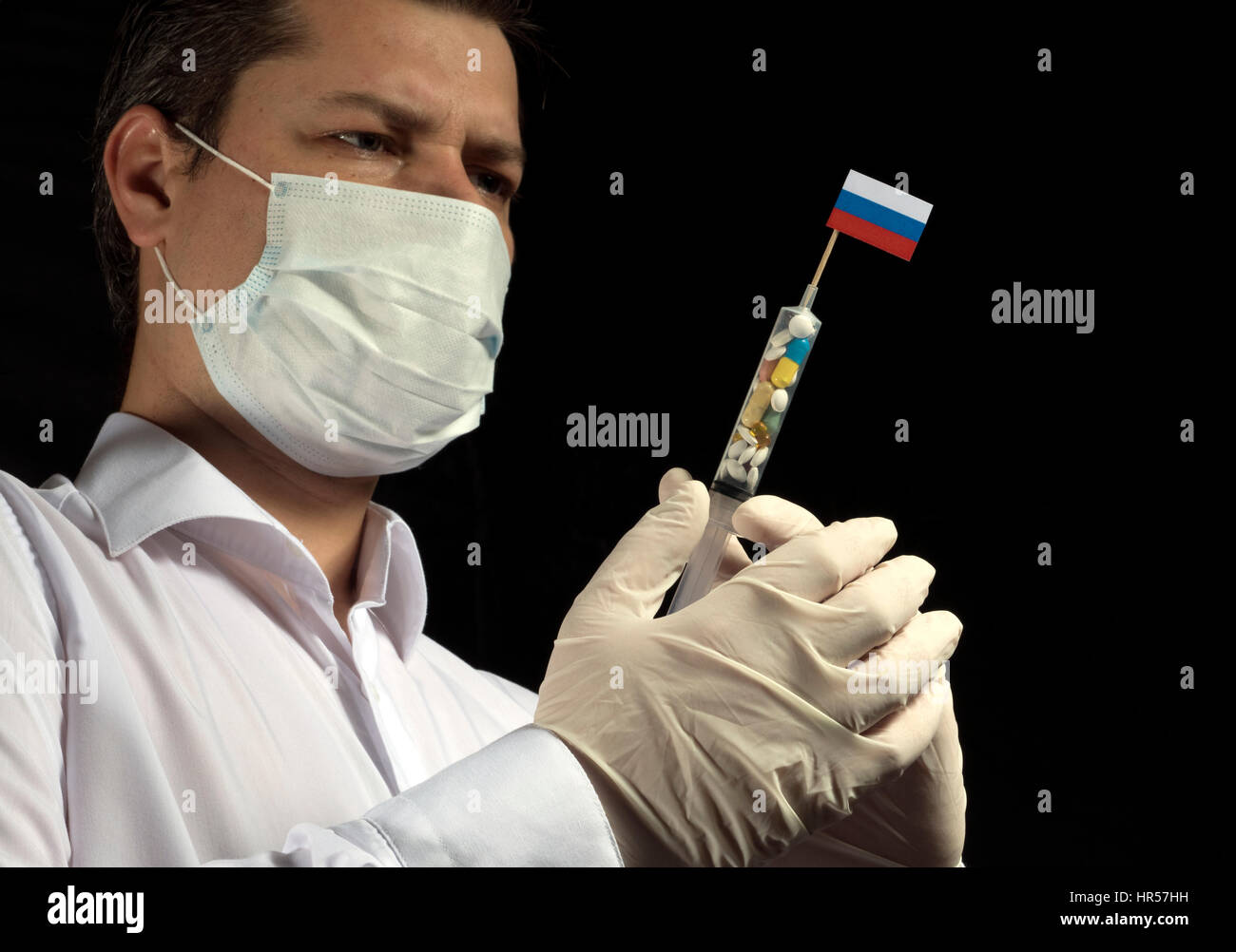 Young man as a doctor gives a medical injection to Russian flag on a ...