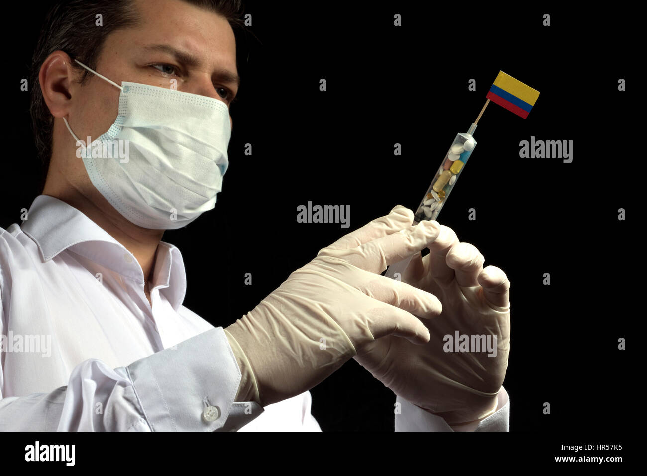 Young man as a doctor gives a medical injection to Colombian flag on a ...