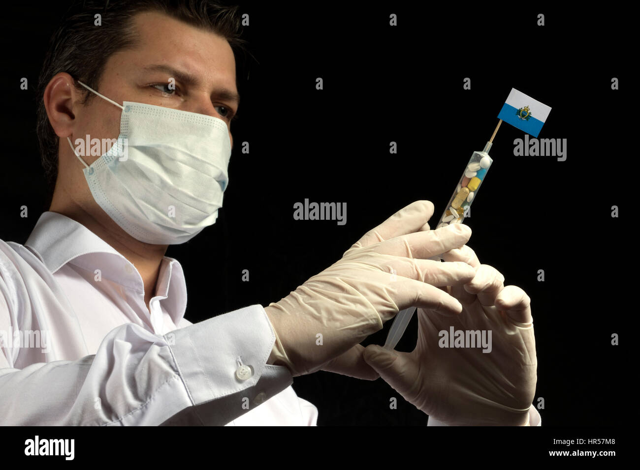 Young man as a doctor gives a medical injection to San Marino flag on a ...