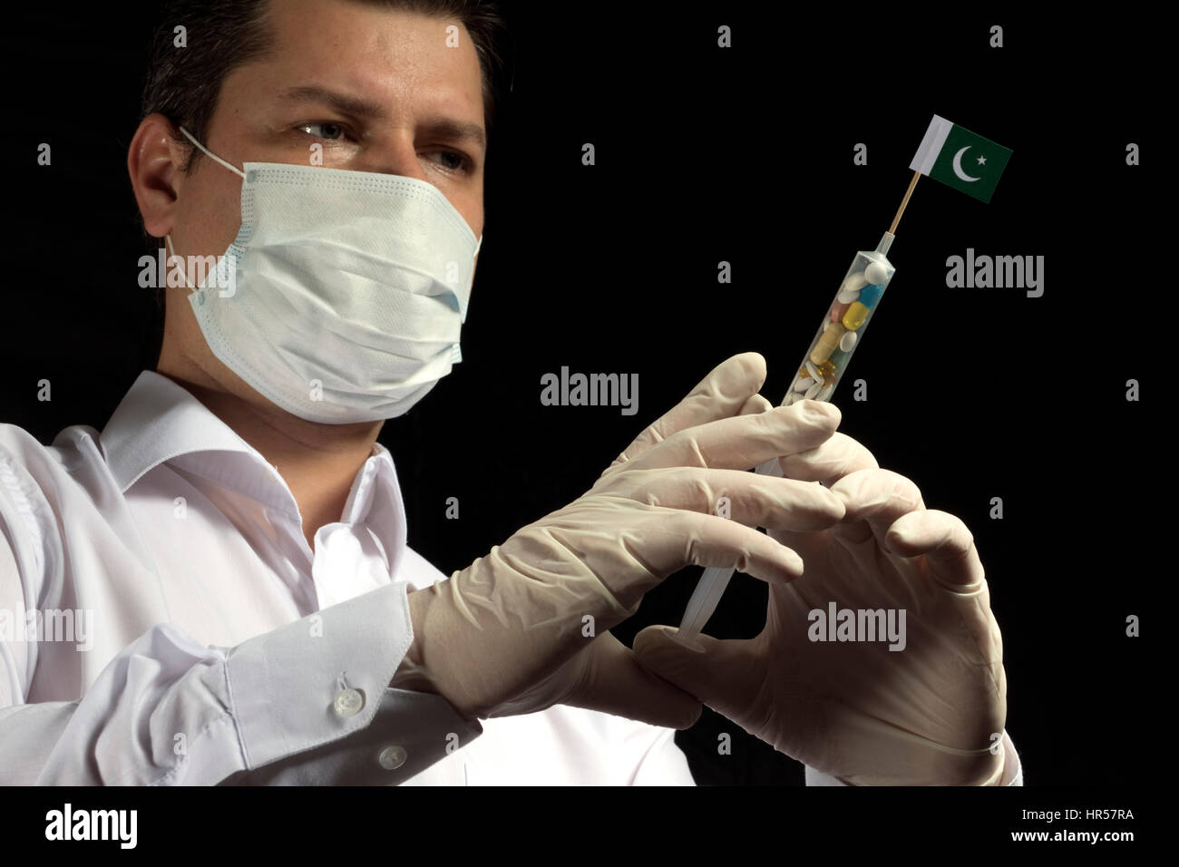 Young man as a doctor gives a medical injection to Pakistani flag on a ...