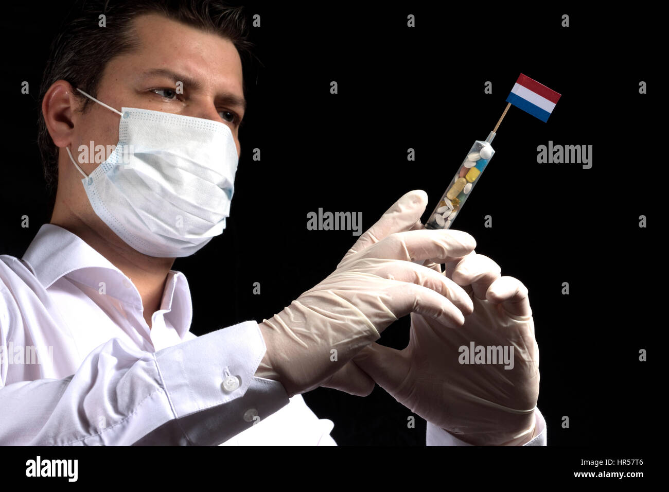 Young man as a doctor gives a medical injection to Dutch flag on a ...