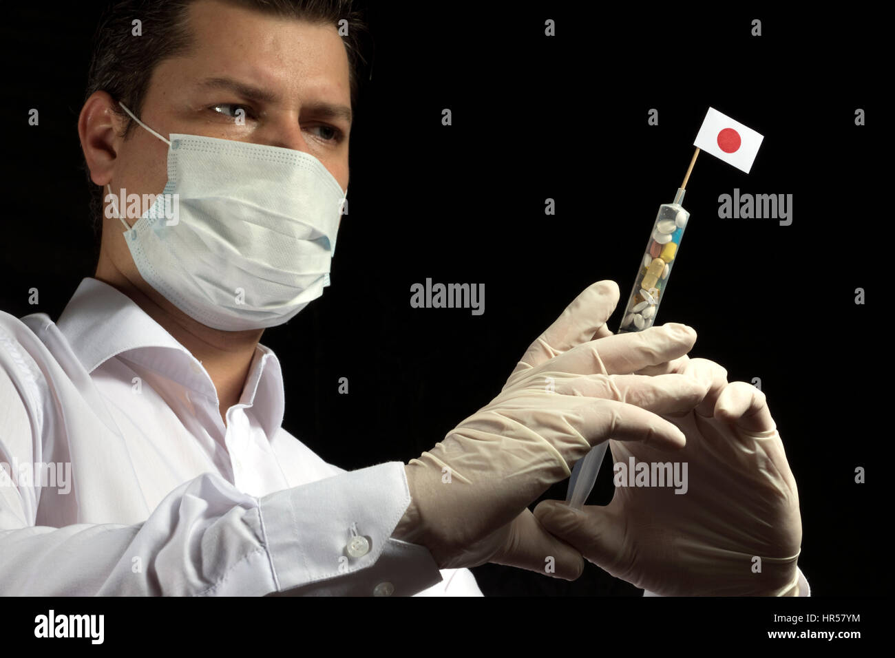 Young man as a doctor gives a medical injection to Japanese flag on a ...
