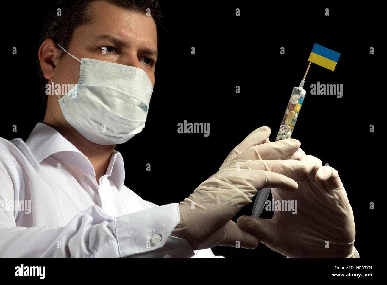 Young man as a doctor gives a medical injection to Ukrainian flag on a ...