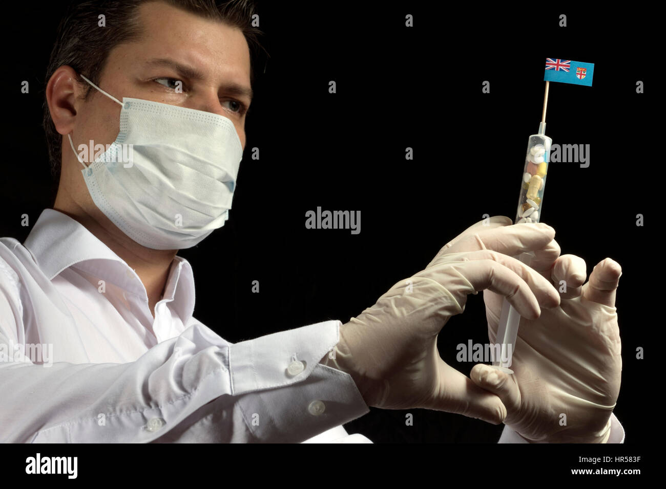 Young man as a doctor gives a medical injection to Fijian flag on a ...