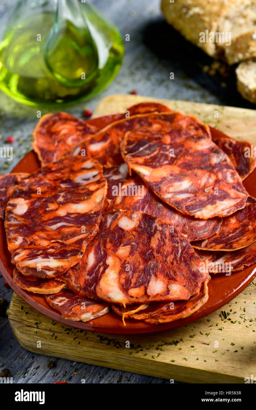 closeup of an earthenware plate with some slices of spanish chorizo, a ...