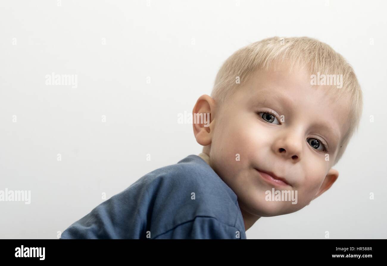 Little Caucasian boy looking at the camera over his shoulder Stock ...