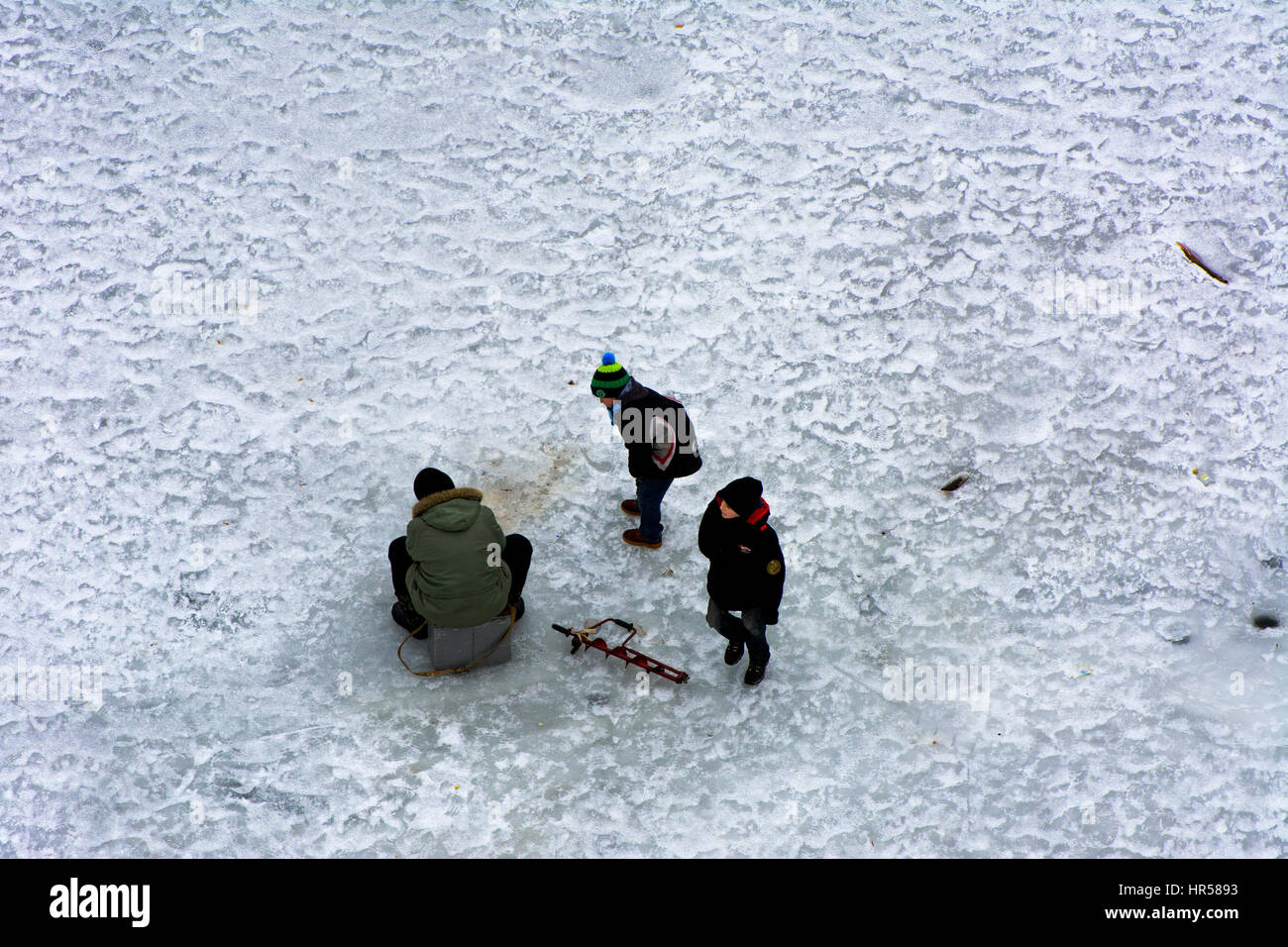 Fishermen on the river in winter ice fishing before the ice melting ...