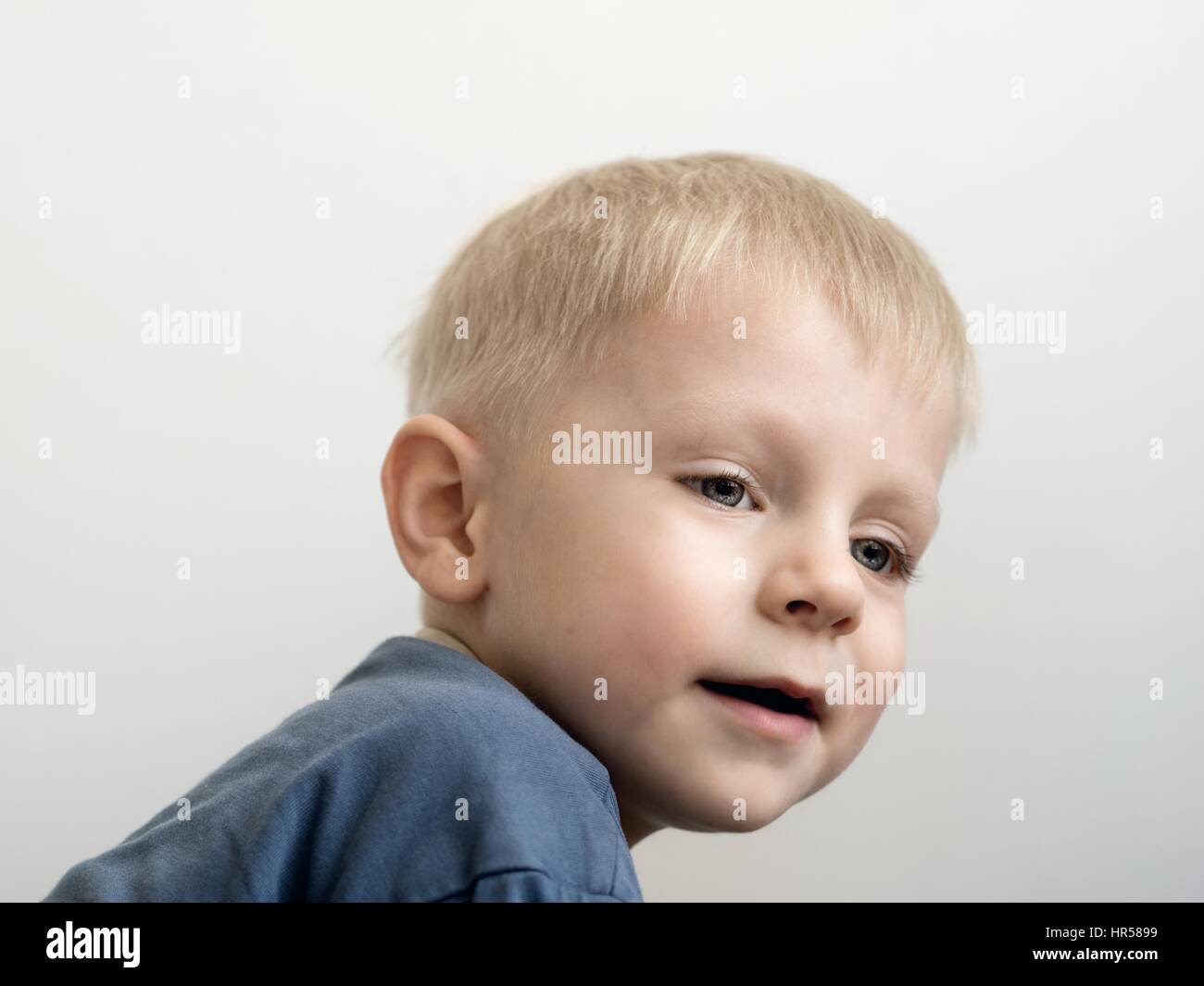 Little Caucasian boy looking at the camera over his shoulder Stock ...