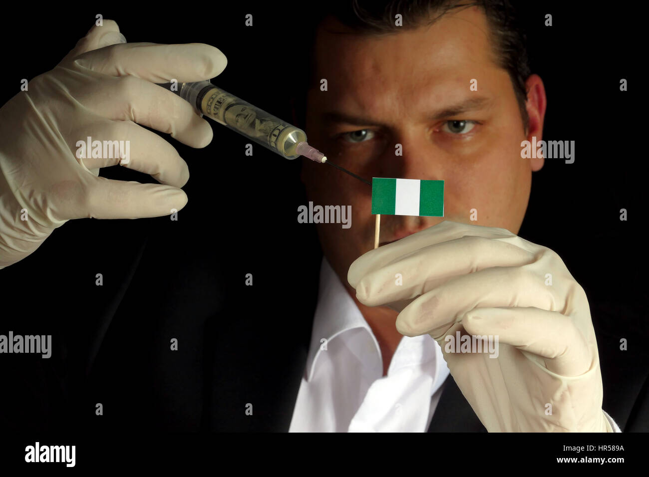Young businessman gives a financial injection to Nigerian flag isolated ...