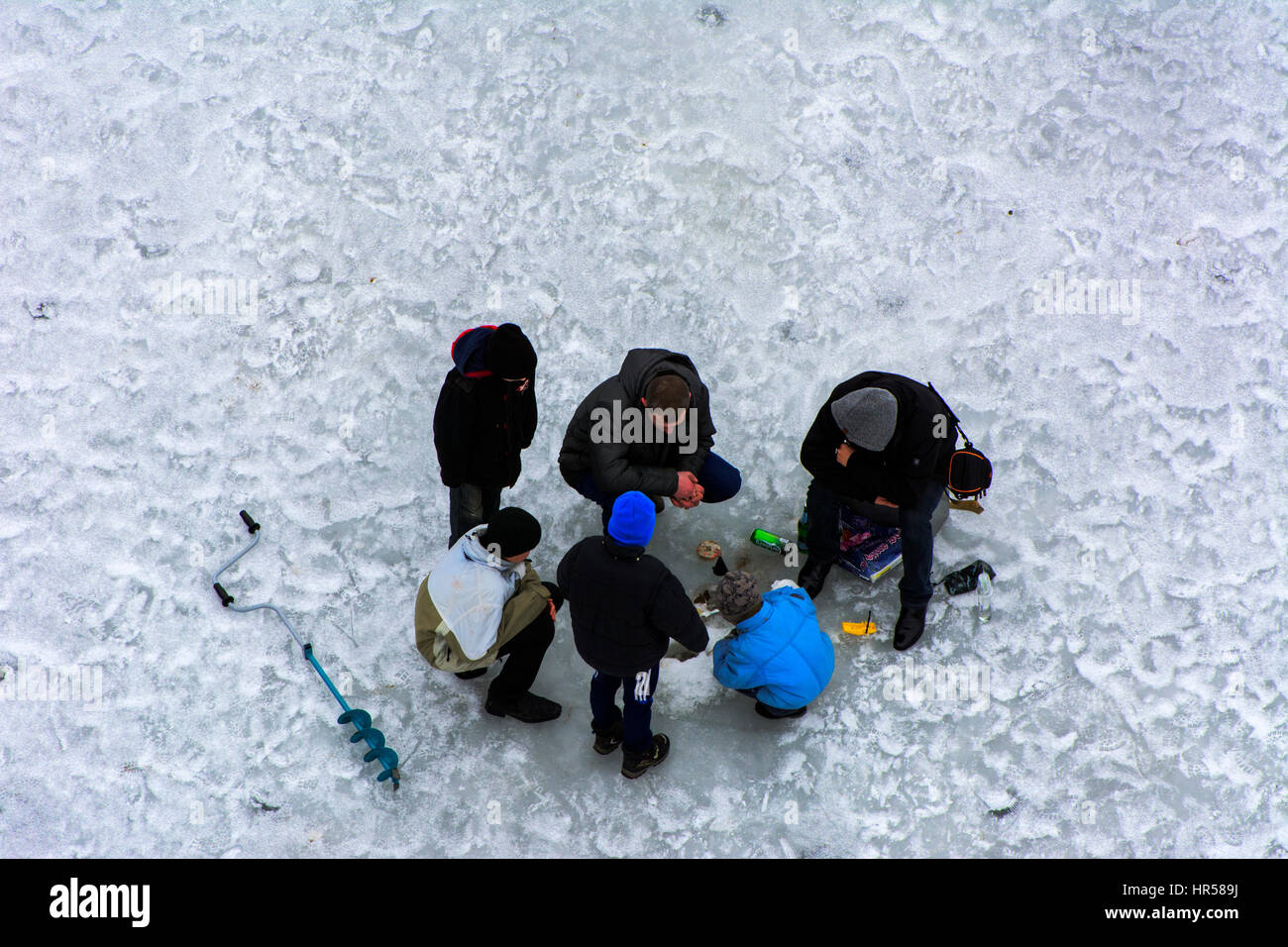 Fishermen on the river in winter ice fishing before the ice melting ...