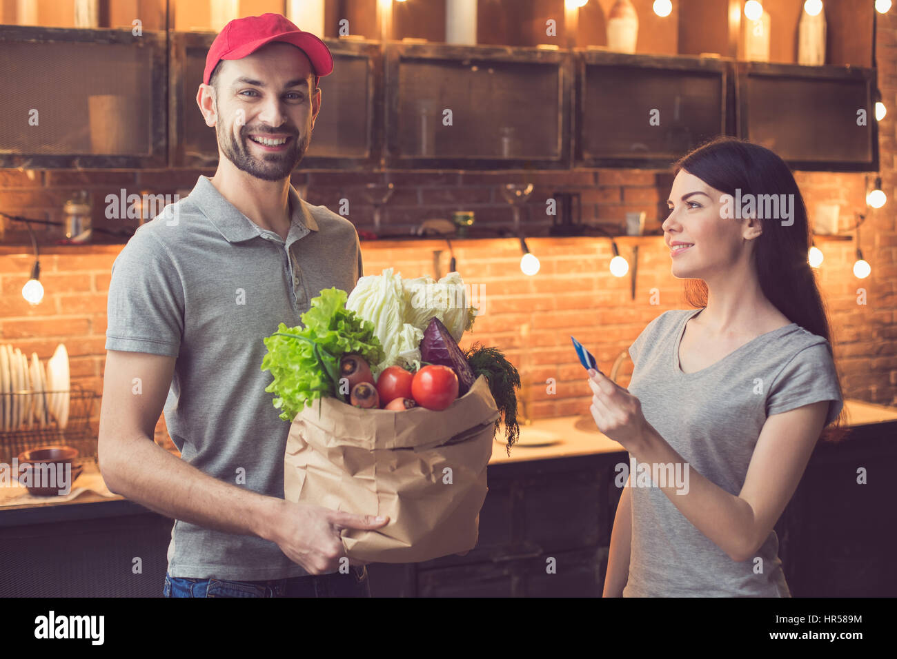 Food delivery service. Young man smiling and looking at camera while ...
