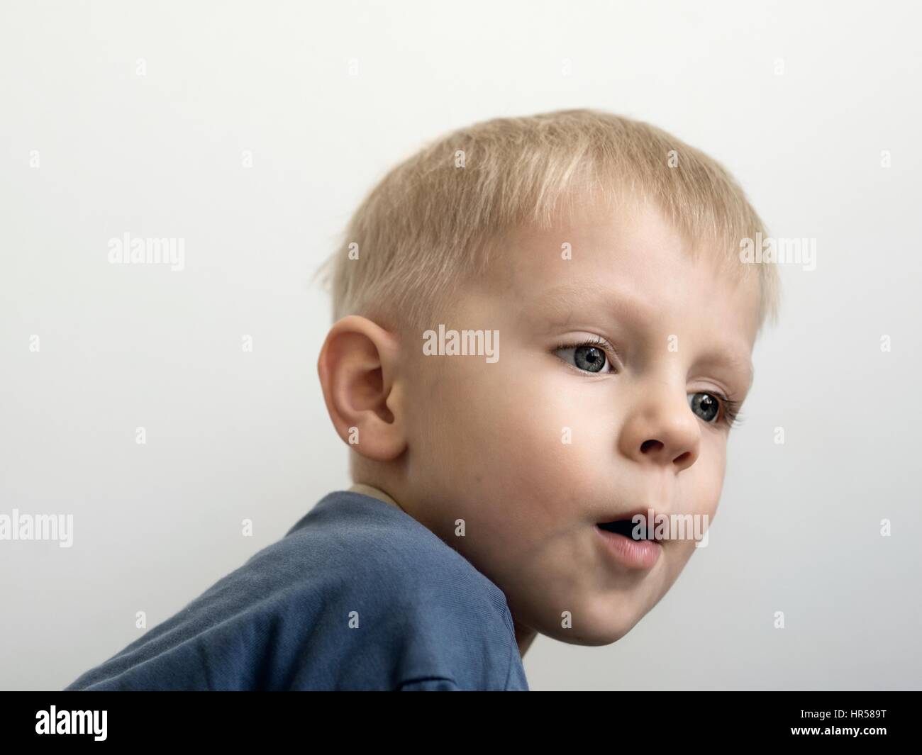 Little Caucasian boy looking at the camera over his shoulder Stock ...