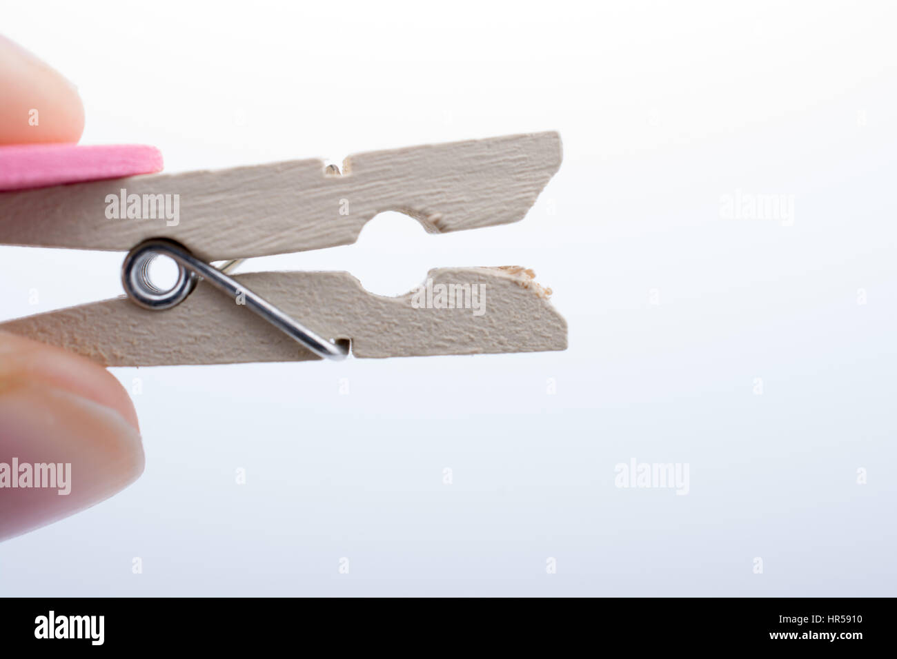 Hand holding a small wooden clothespin in hand Stock Photo - Alamy