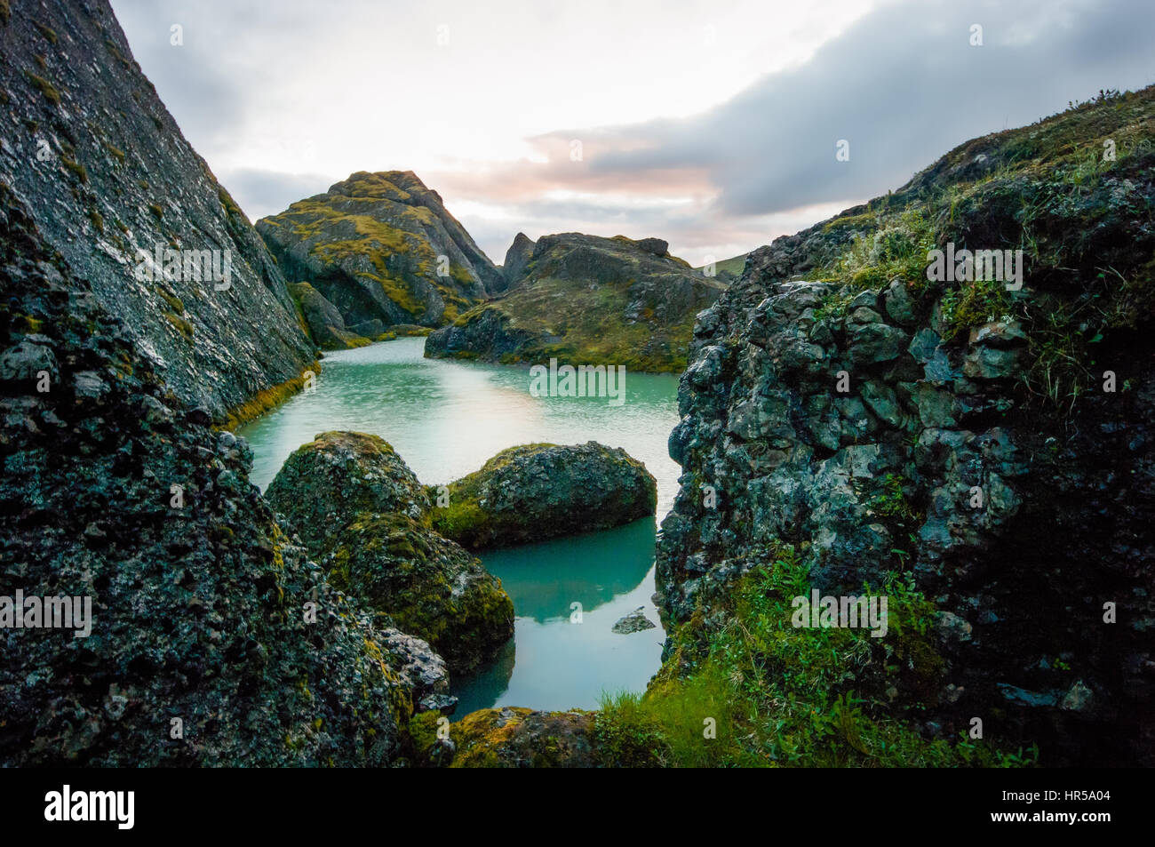 View of pristine remote pond between two giant boulders in Iceland ...