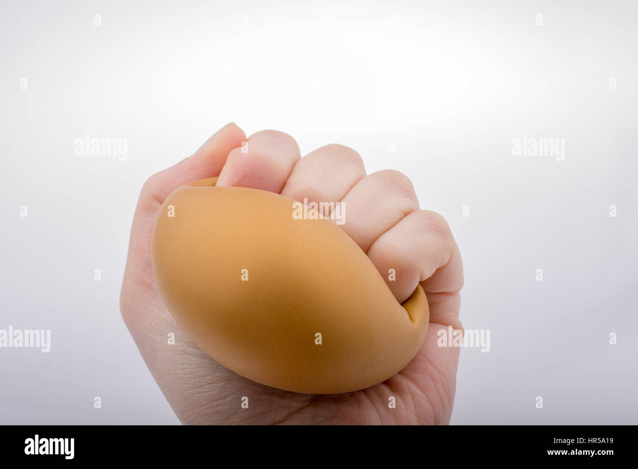Squeezing yellow balloon with hand on a white background Stock Photo ...