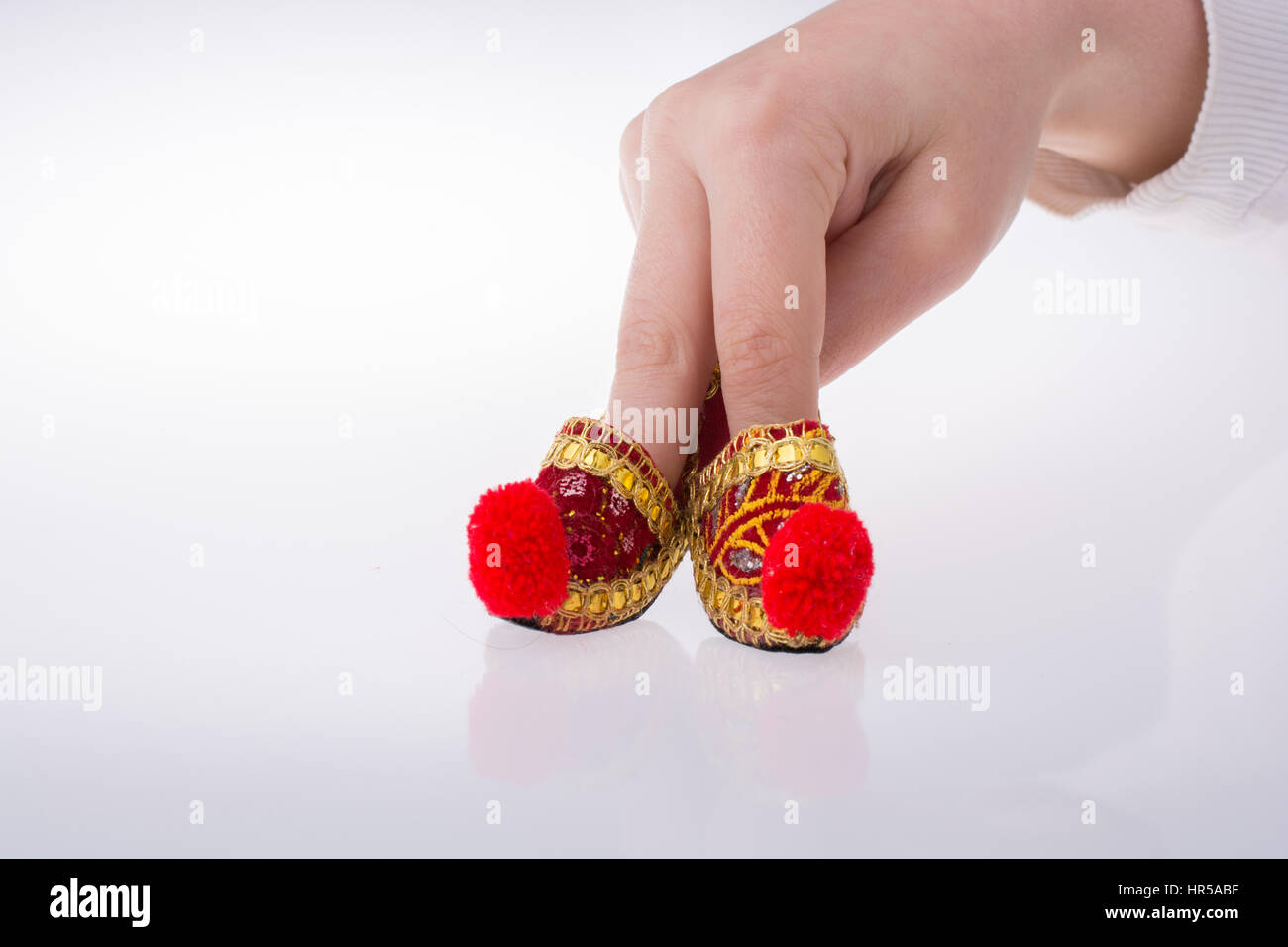 Hand holding traditional Turkish handmade shoes on white background ...