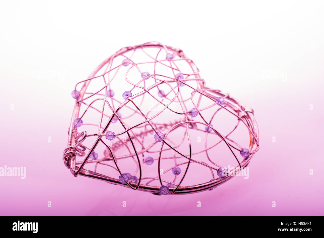Heart shaped cage on a pink background Stock Photo - Alamy