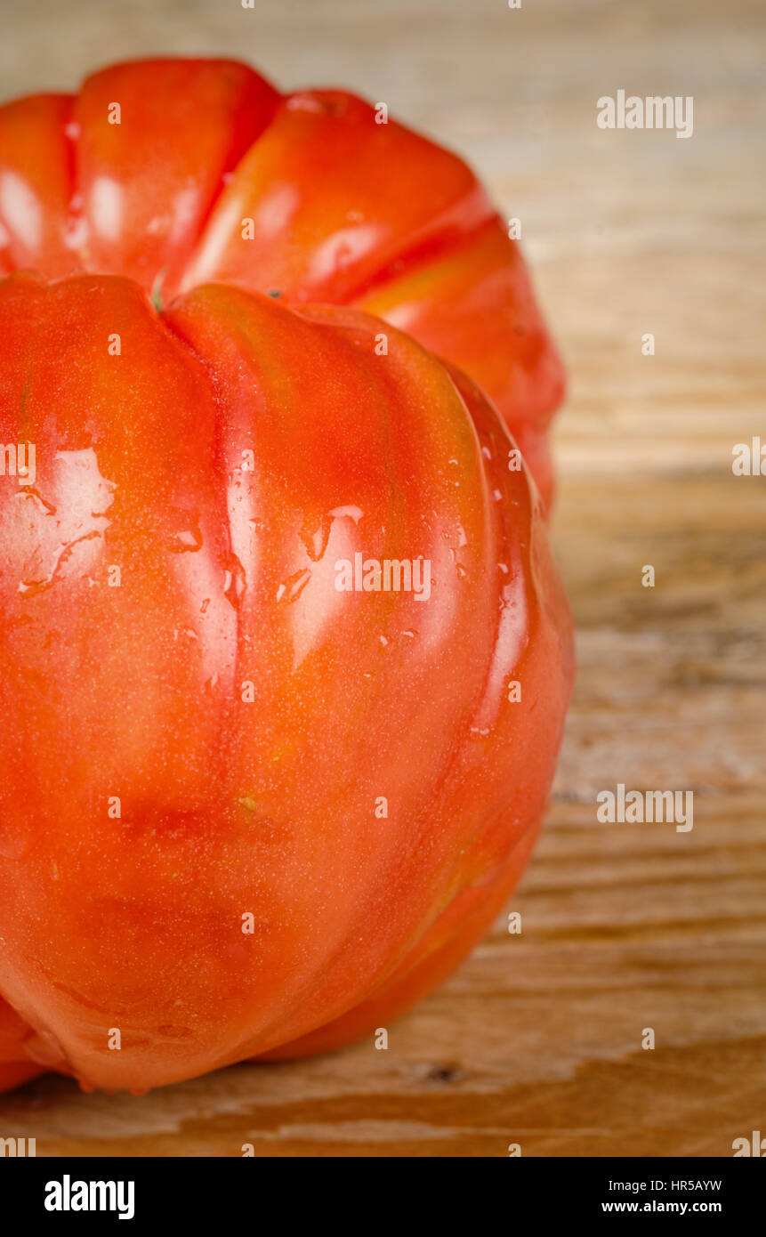 Wrinkled tomato of the particularly tasty Raf type on a rustic wooden ...